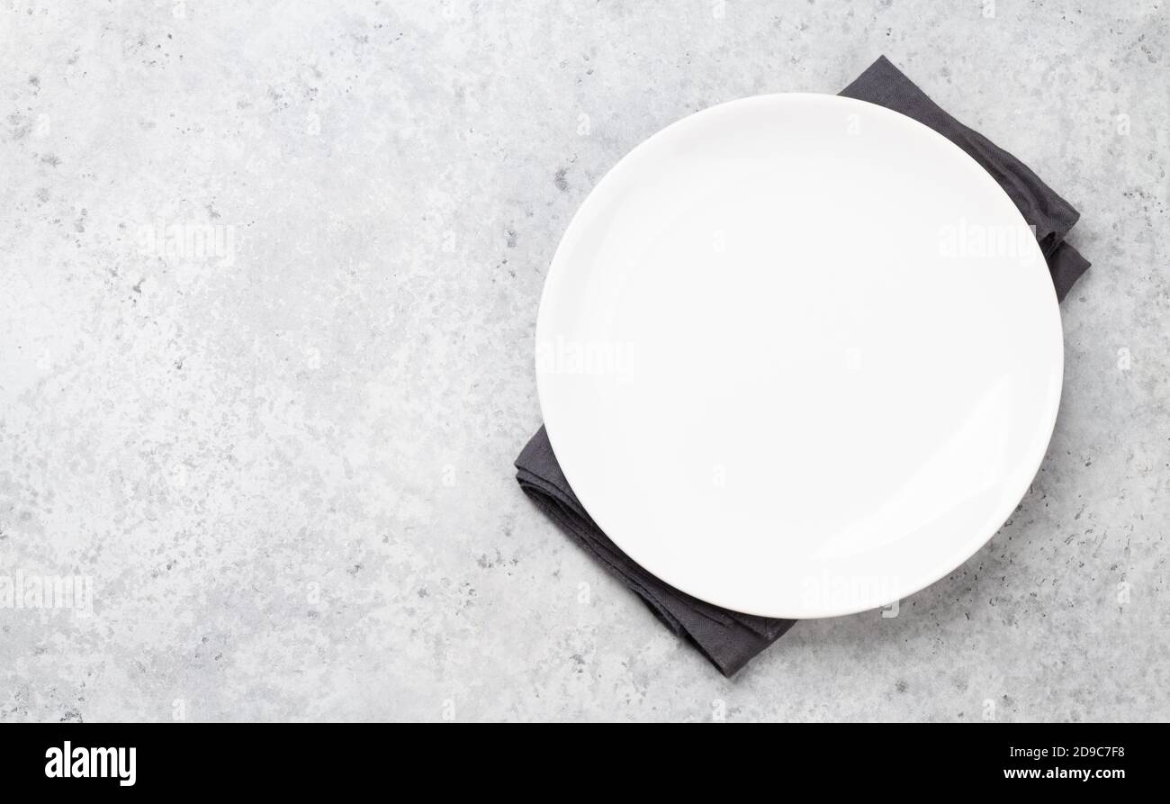 White empty plate and napkin on stone table. Top view flat lay with ...