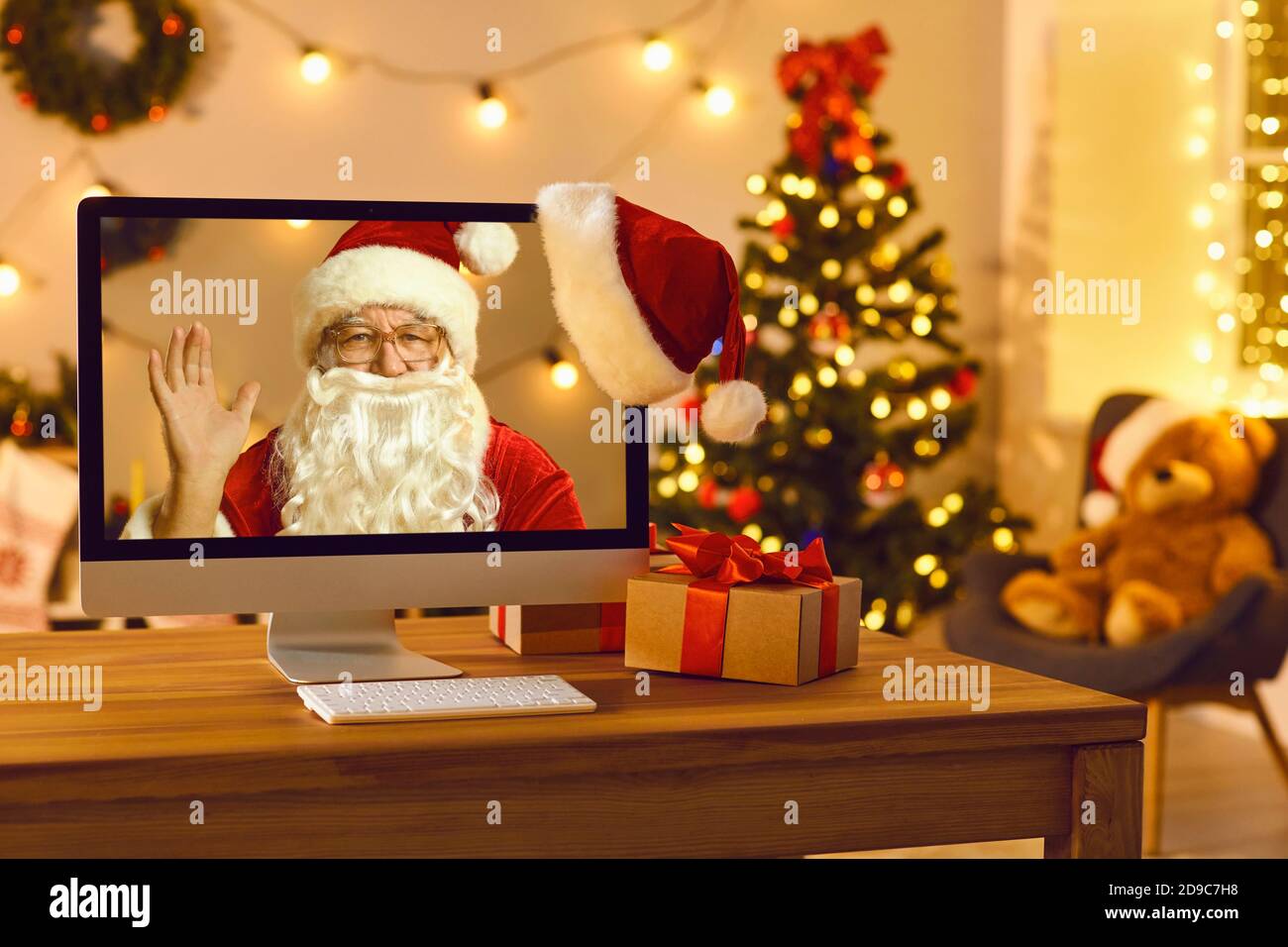 Computer standing on table in cozy room with old Father Christmas on ...