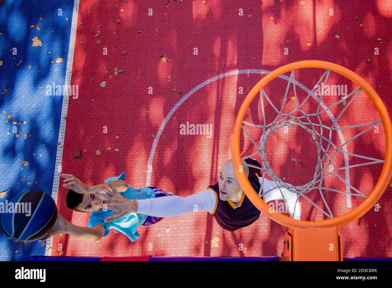 Brothers playing basketball One On One on outdoor court. Shooting at ...