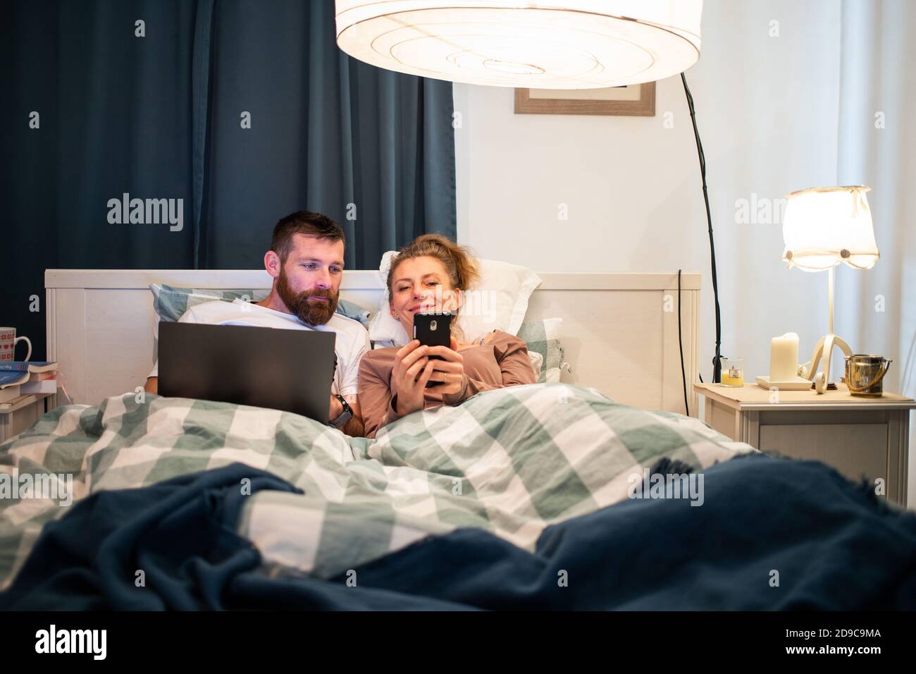 couple in bed with laptop Stock Photo - Alamy