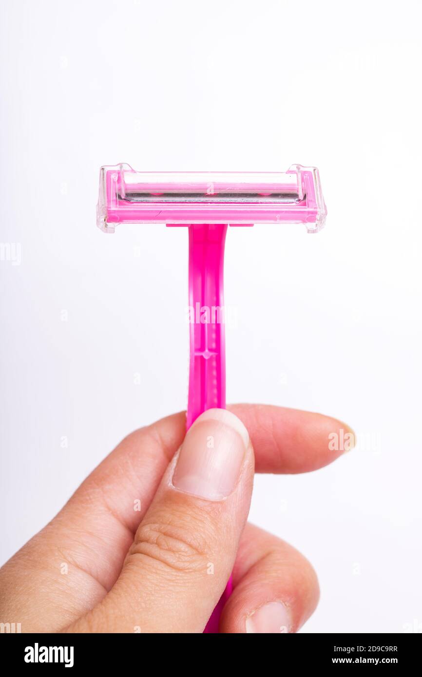 Pink razor in hand on white background Stock Photo - Alamy