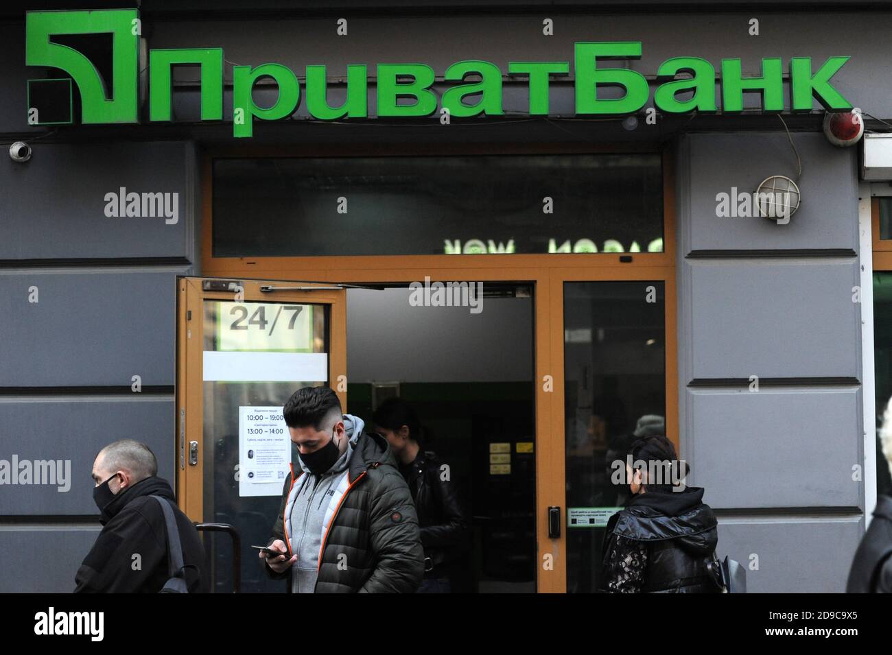 People wearing black face masks as a precaution exits at the Privatbank ...