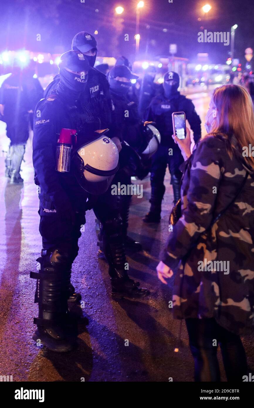 A protester takes a photograph of a riot policeman wearing heavy ...