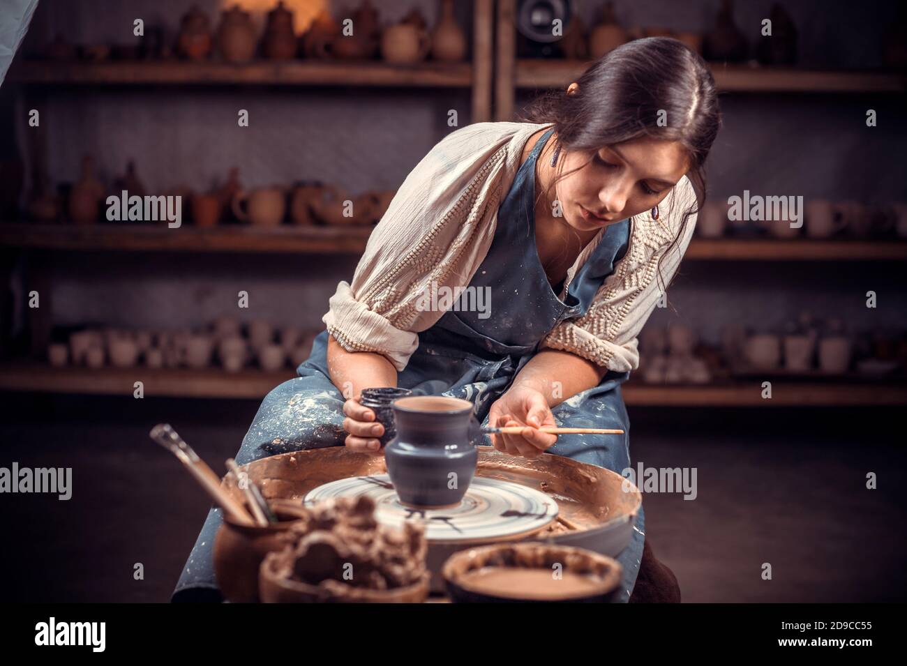 Beautiful young lady making ceramic pot on the pottery wheel . Concept ...
