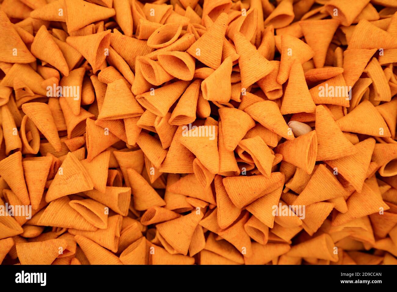 Triangle orange corn chips abstract background texture Stock Photo - Alamy