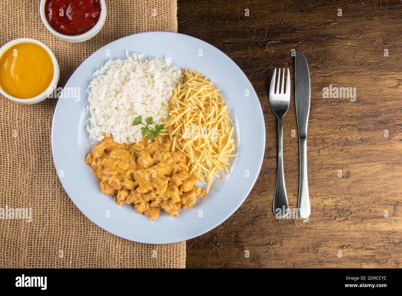 Food dish with chicken stroganoff and rice and chips Stock Photo - Alamy
