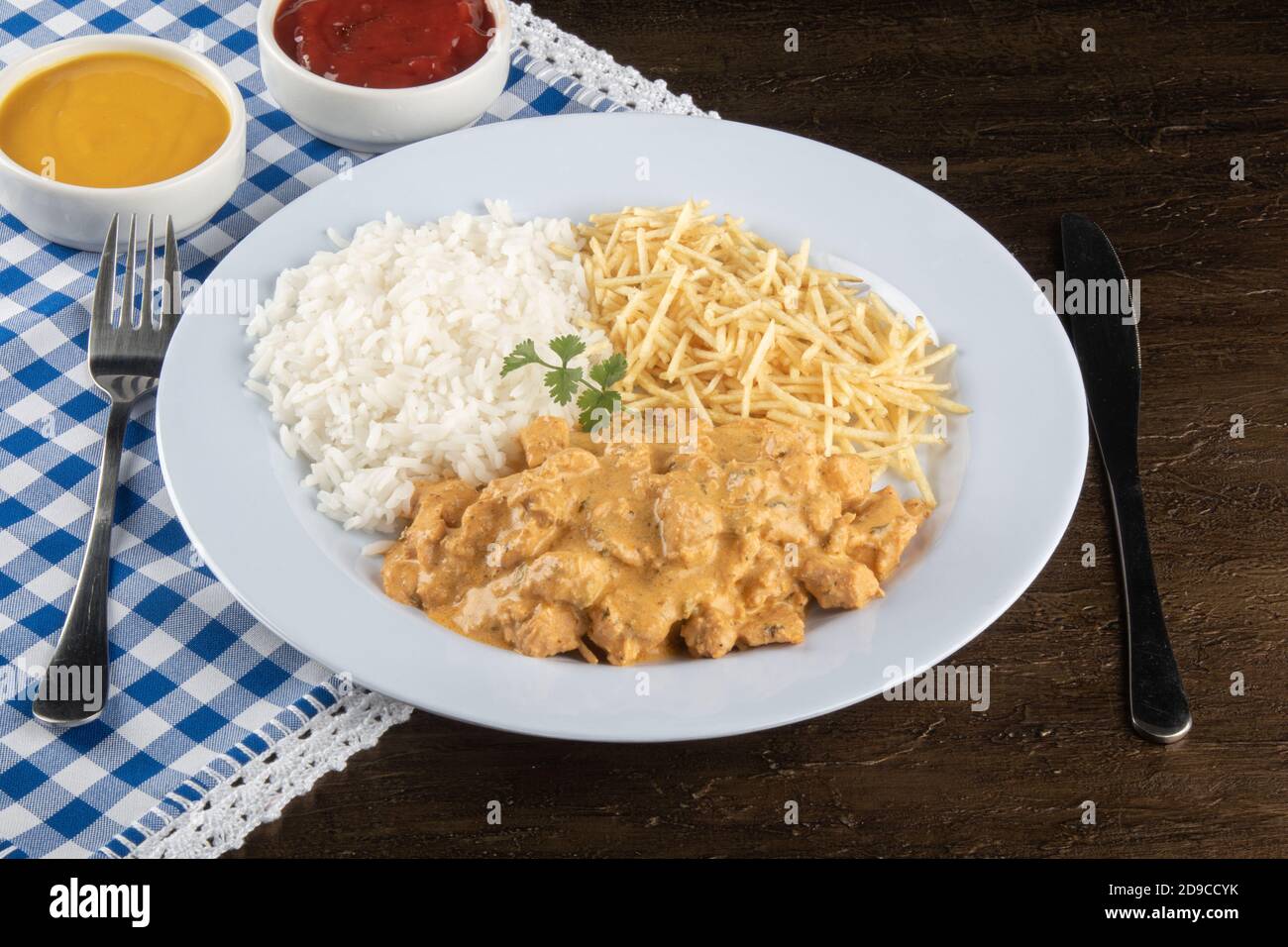 Food dish with chicken stroganoff and rice and chips Stock Photo - Alamy