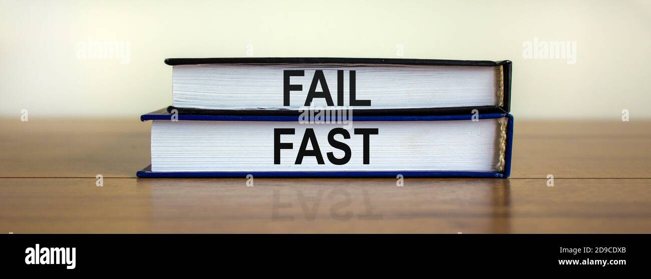 Books with text 'fail fast' on beautiful wooden table. White background ...