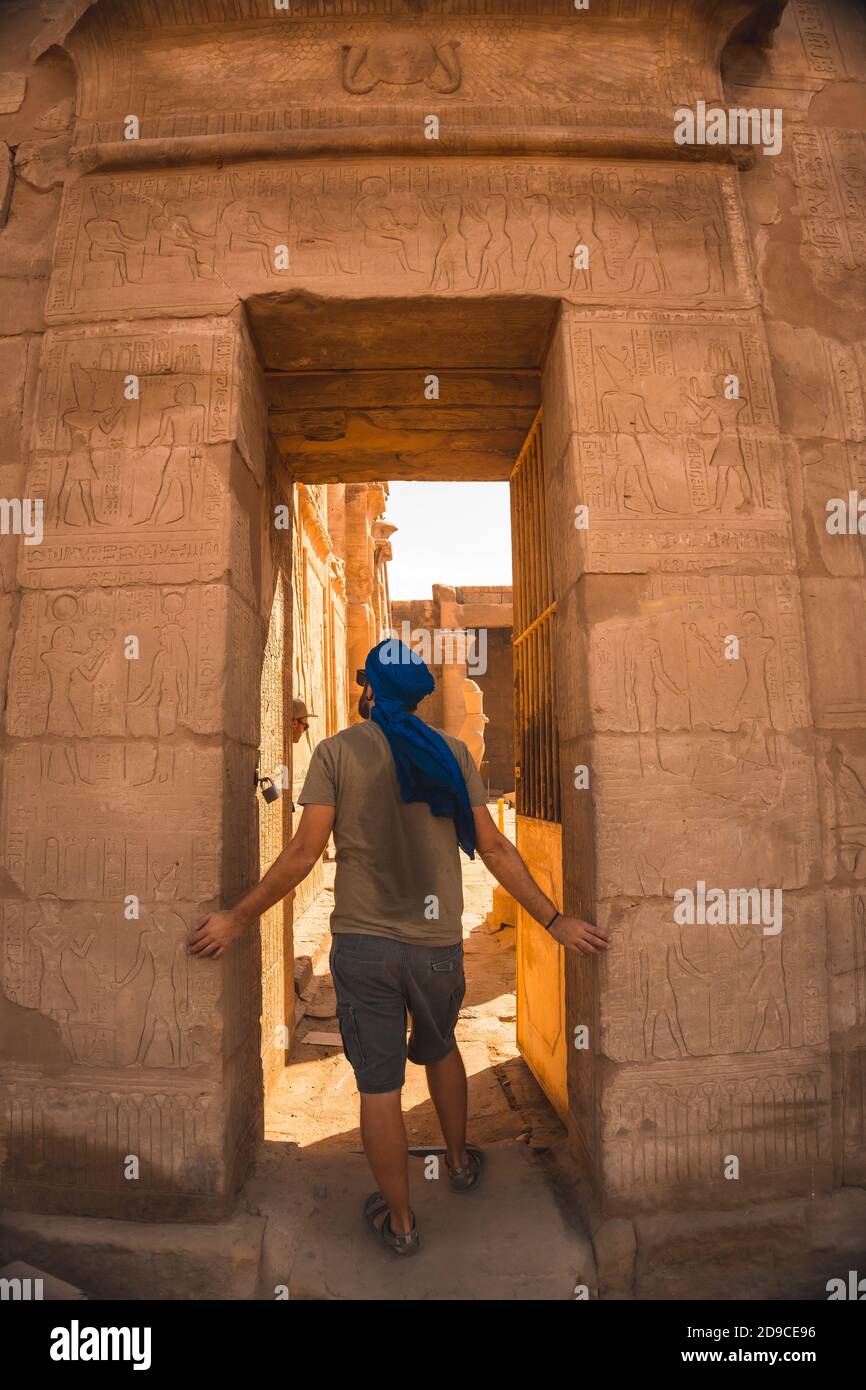Young male wearing a blue Turban and walking around The Temple of Horus ...