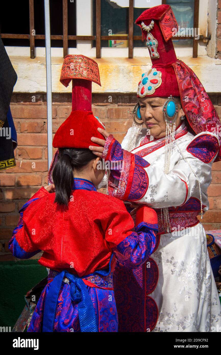 Dressing a child in a traditional Mongolian costume for a dance at a ...