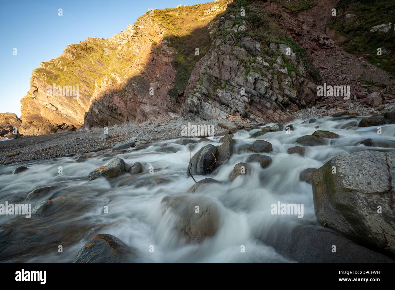Long exposure of the river Heddon flowing onto the beach at Heddons ...