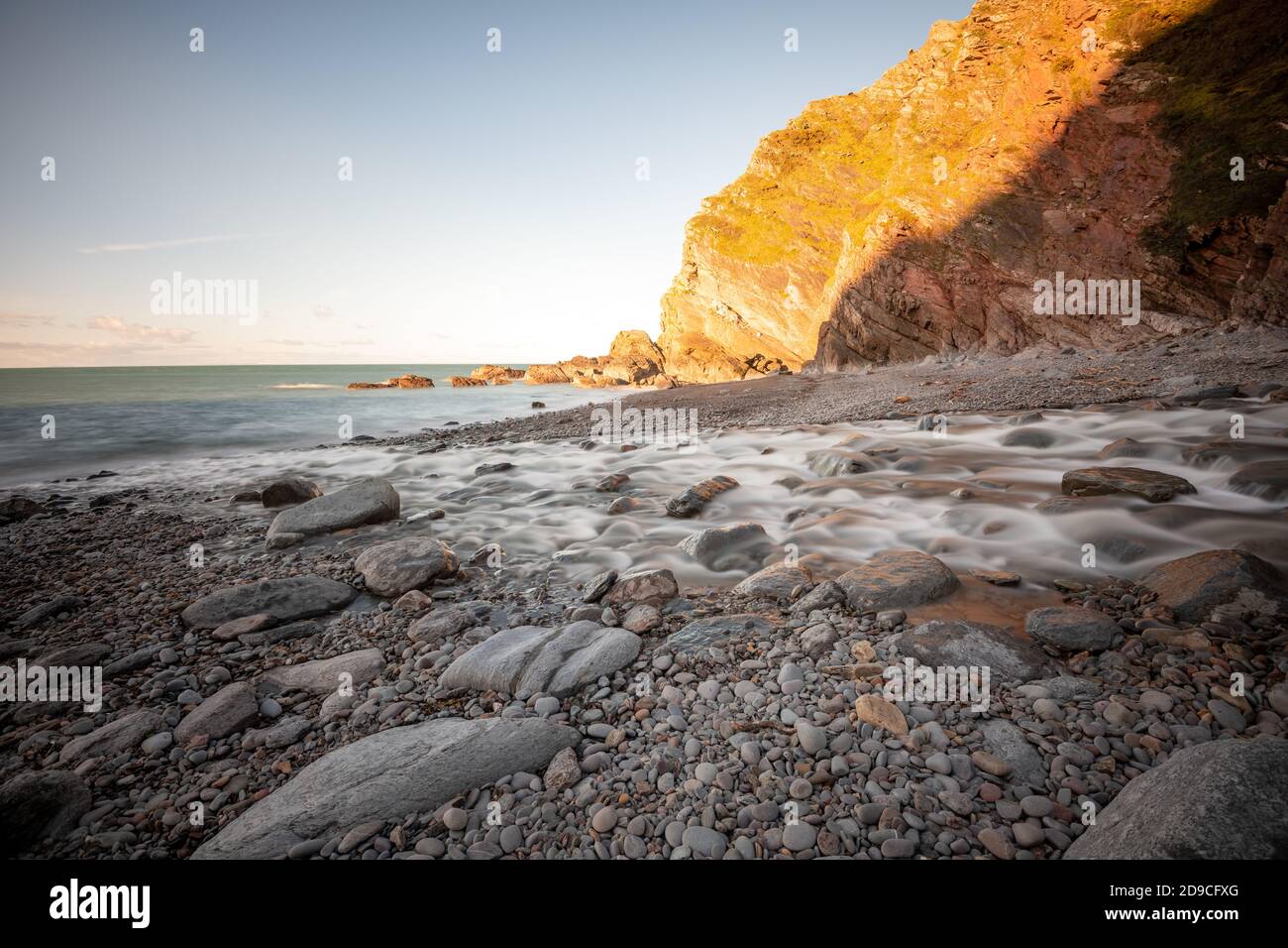Long exposure of the river Heddon flowing onto the beach at Heddons ...