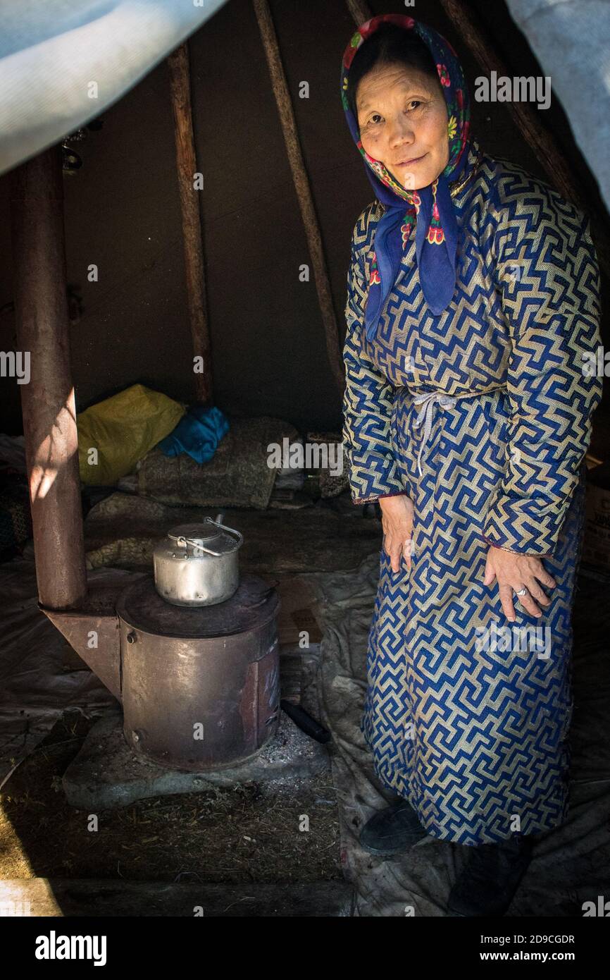 The Dukha people domesticate reindeer, this Dukha woman stands inside ...