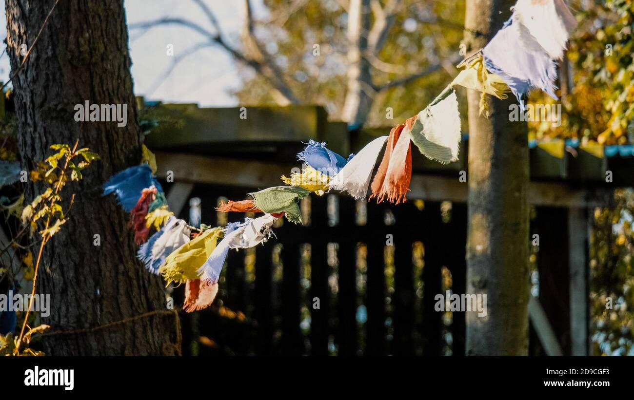 Closeup of small colorful cloth pieces hanging from a thread secured on ...