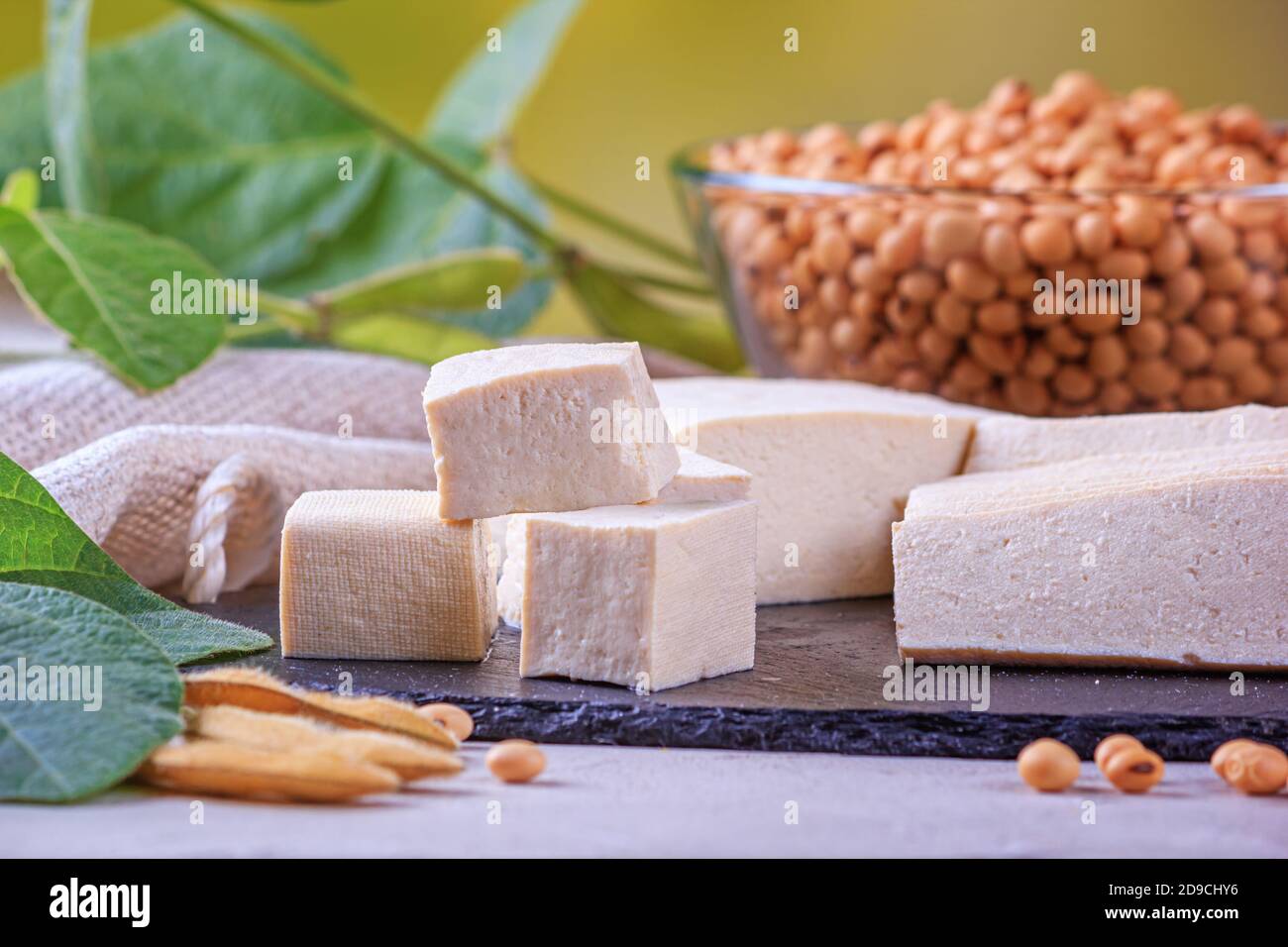 Tofu, also known as bean curd, diced on the black surface of the slate ...