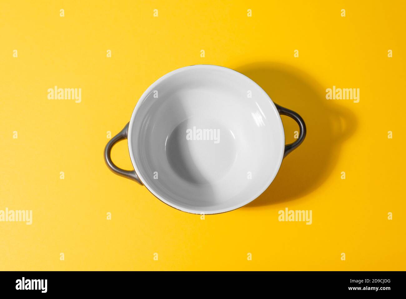 Top view on a deep bowl with handles on yellow background Stock Photo ...