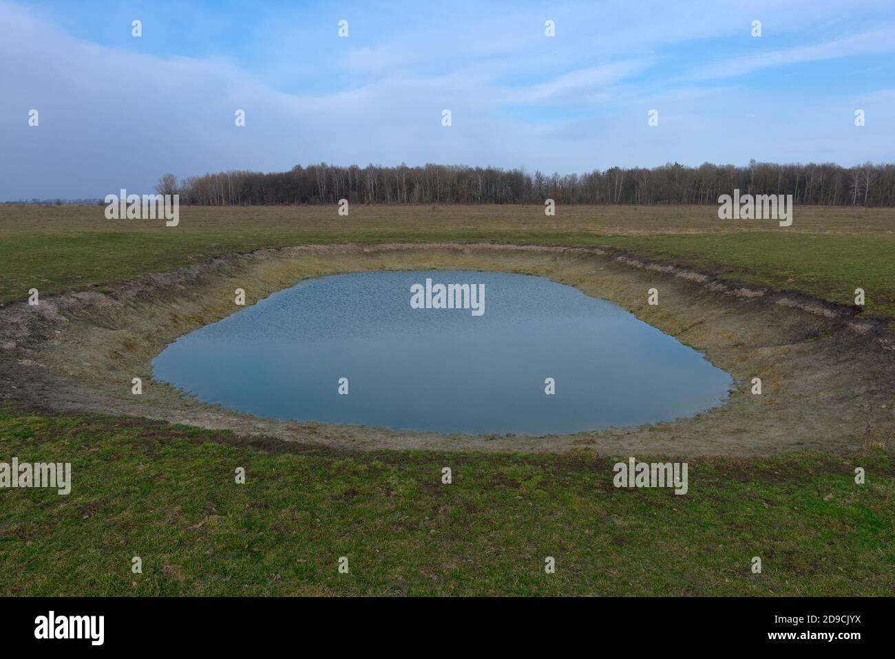 Small artificial shallow reservoir. A beautifully colored pond. Spring ...