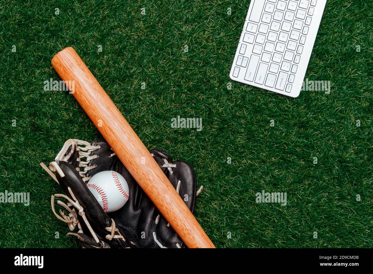 Baseball bat, ball, glove and computer keyboard isolated on a field of ...