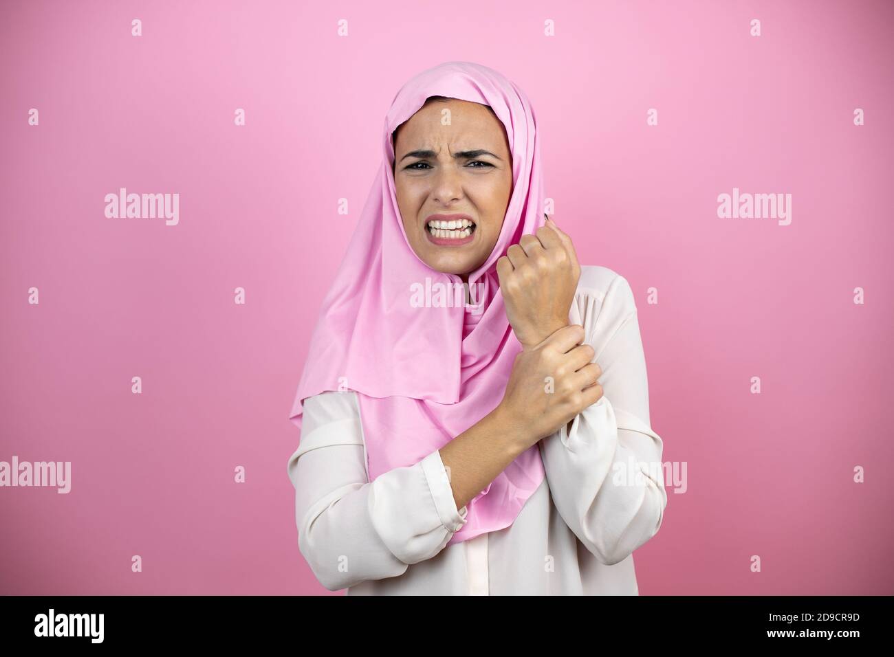 Young beautiful arab woman wearing islamic hijab over isolated pink ...