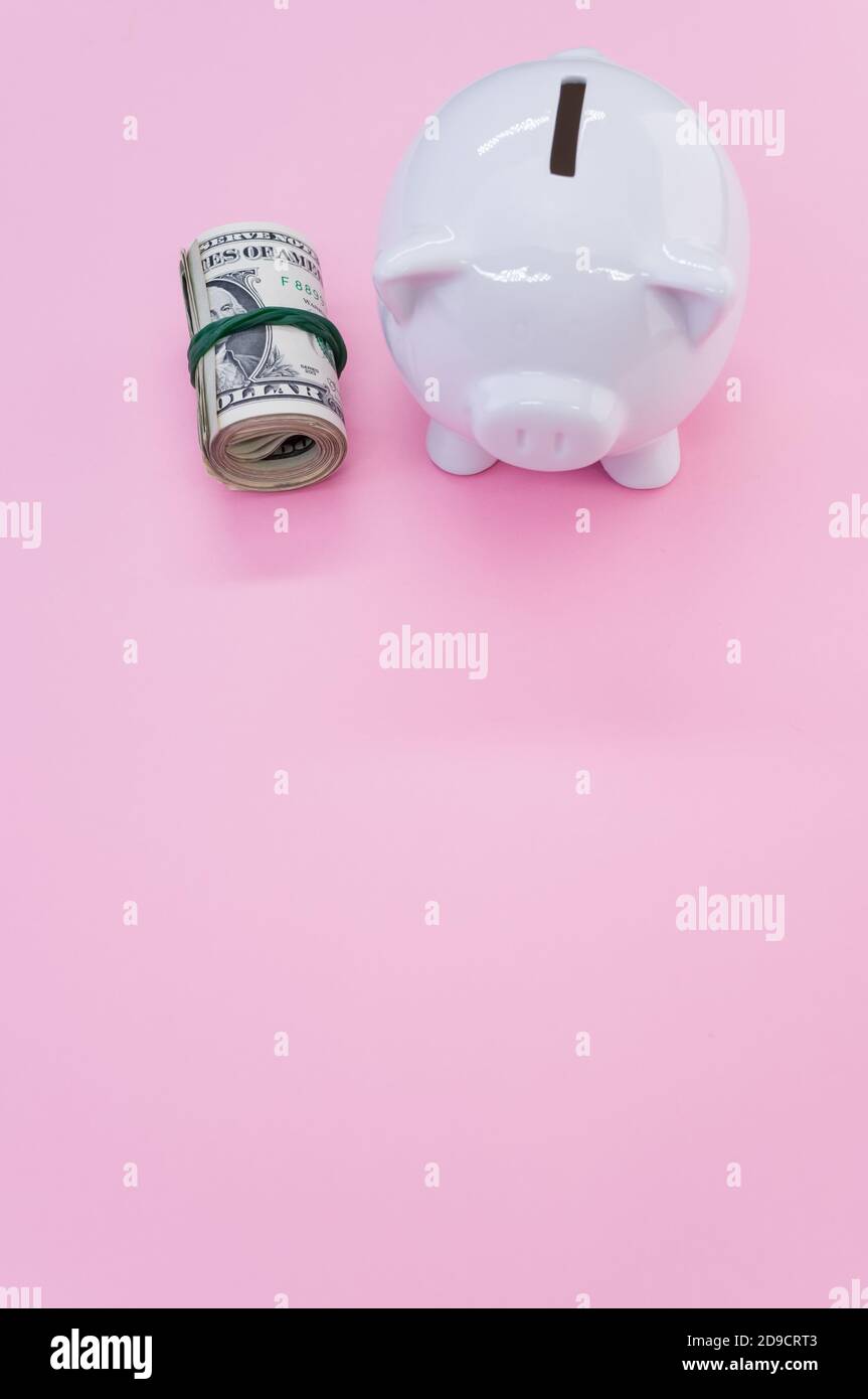 Vertical shot of dollar bills and a piggy bank on a pink surface Stock ...
