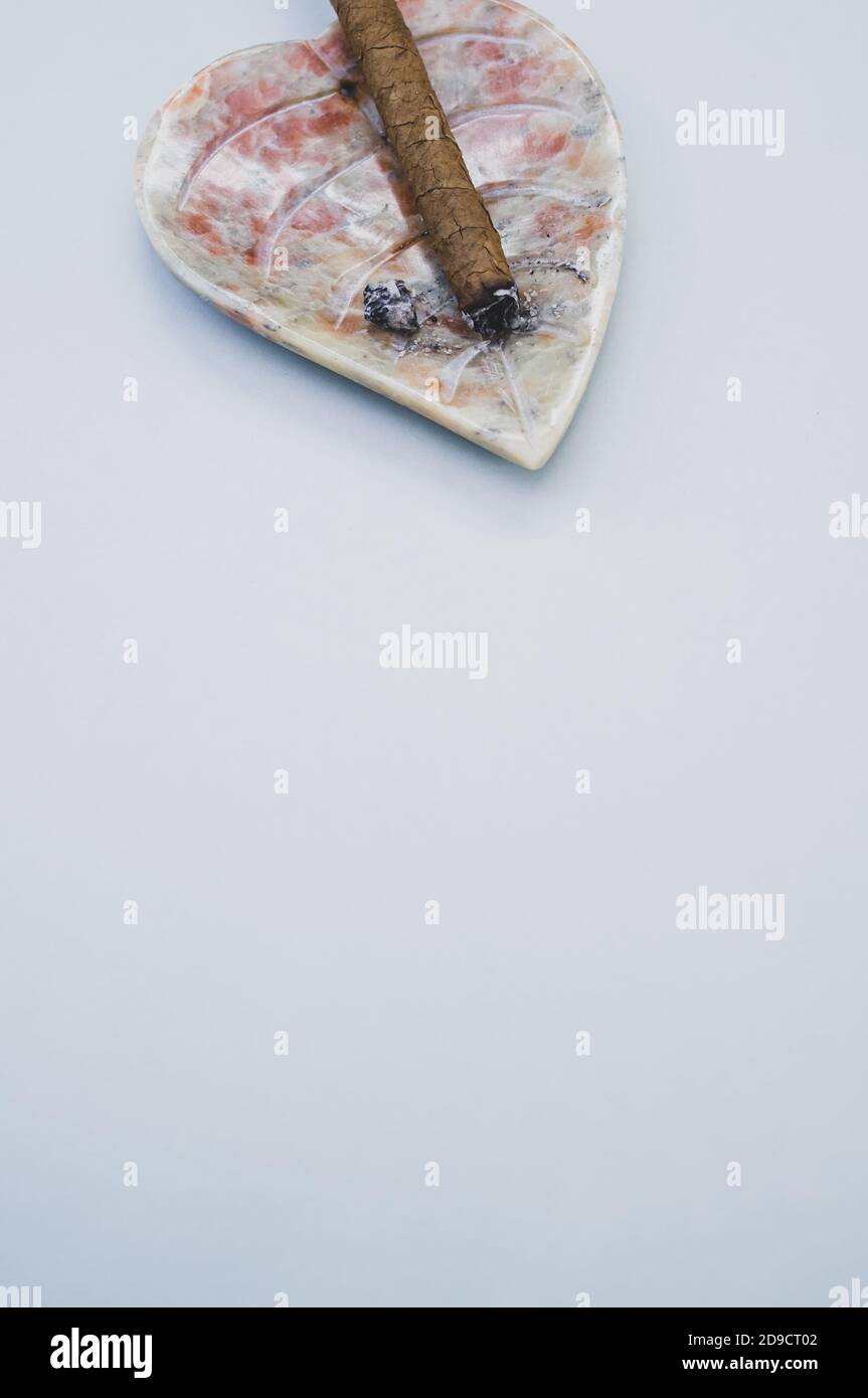 Vertical shot of a cigar on an ashtray on a blue surface Stock Photo ...