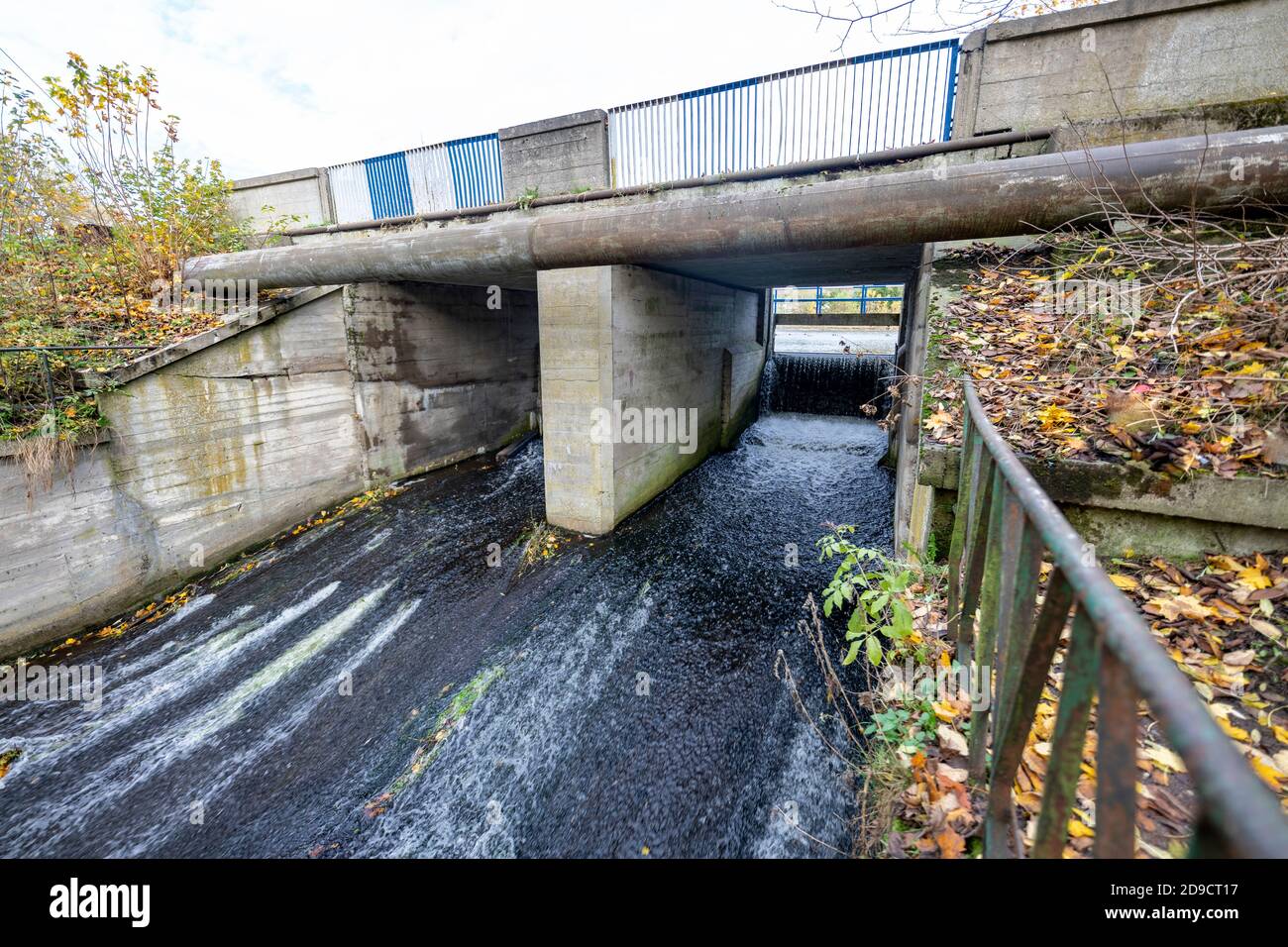 A small dam formed on the river. Road bridge with a small dam. Autumn ...
