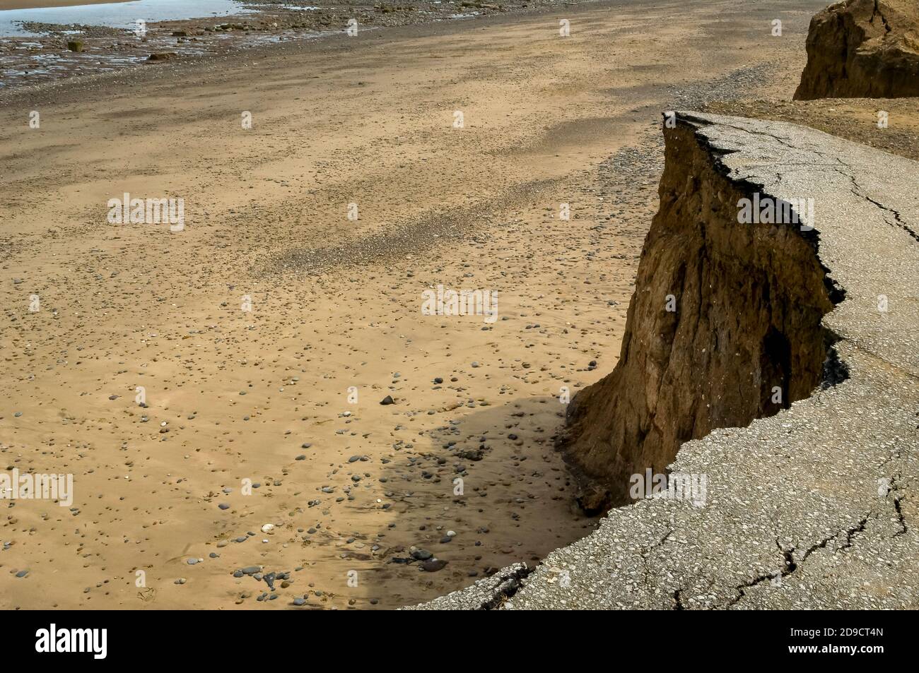 Eroded coastal road at Easington, Humberside, collapsing onto a pebble ...
