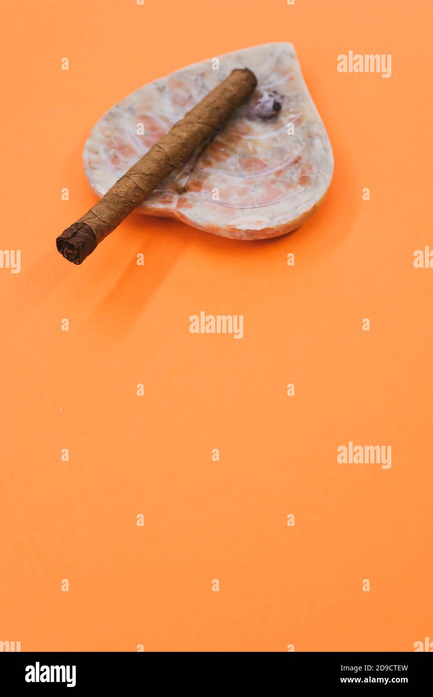 Vertical shot of a cigar on an ashtray on an orange surface Stock Photo ...