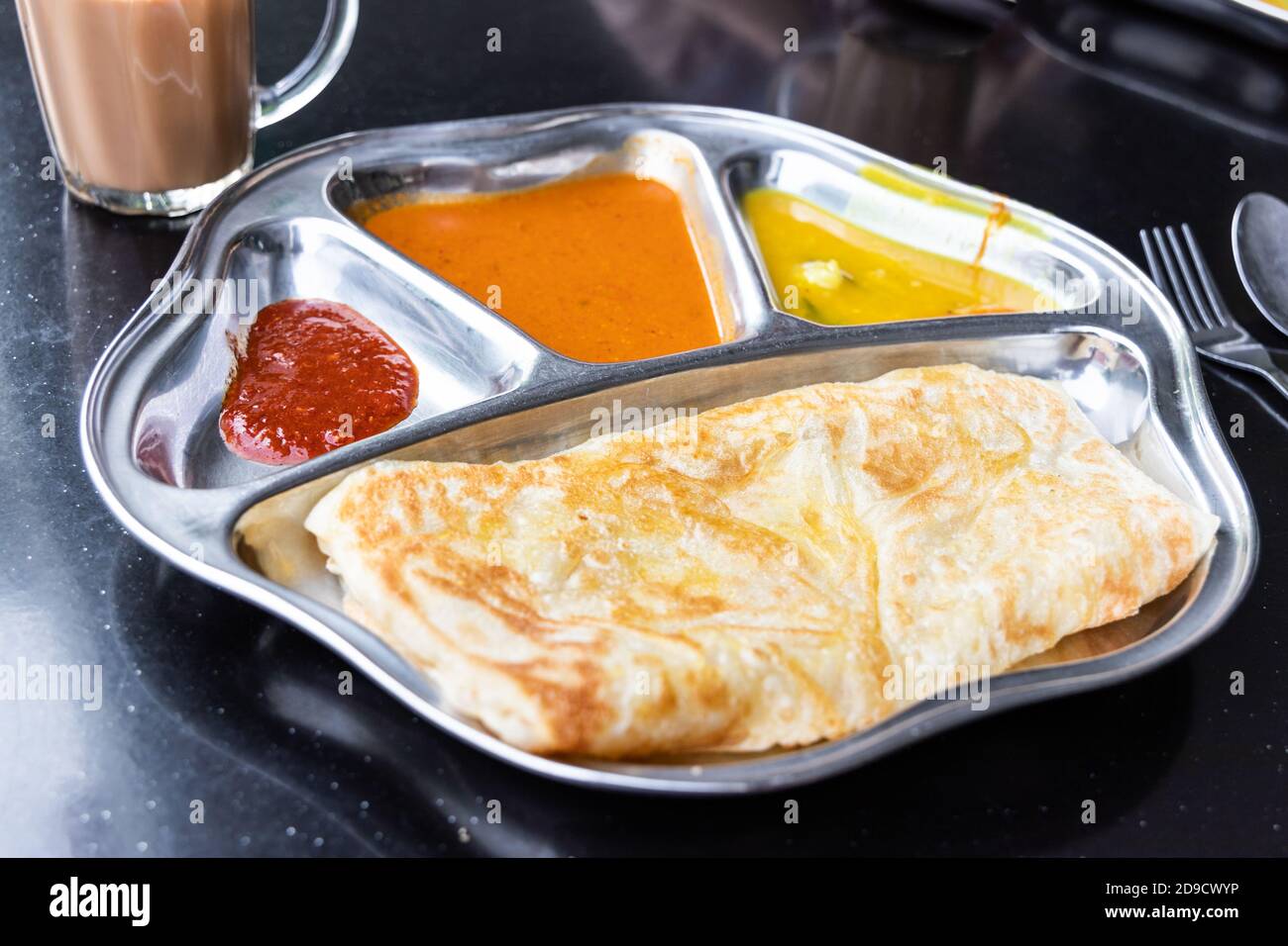 Roti prata or canai set with curry, dhal and sambal Stock Photo - Alamy