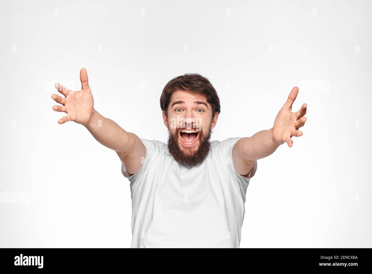 cheerful emotional bearded man gesturing with his hands close-up light ...