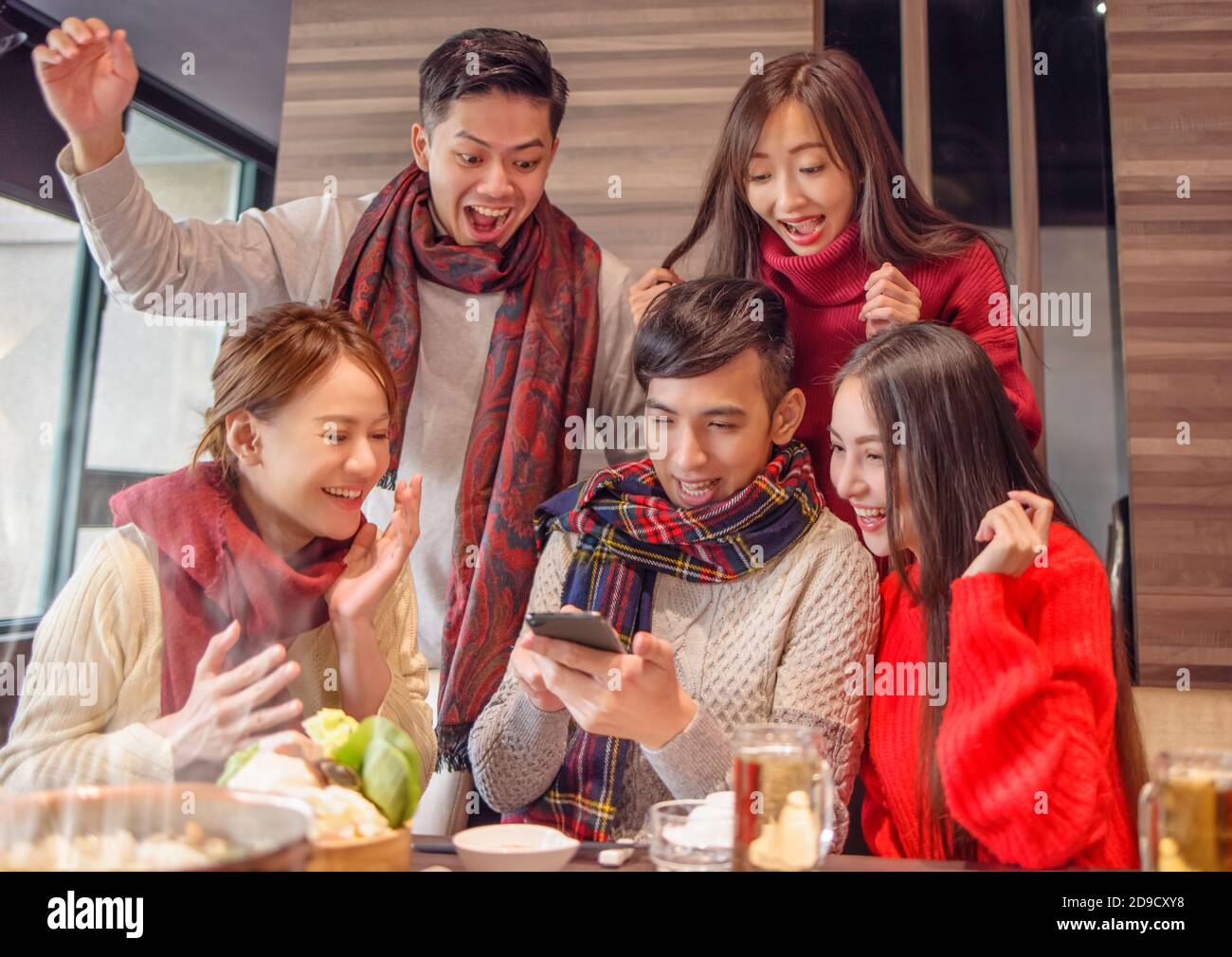 excited friends celebrating good news watching smart phone in the ...