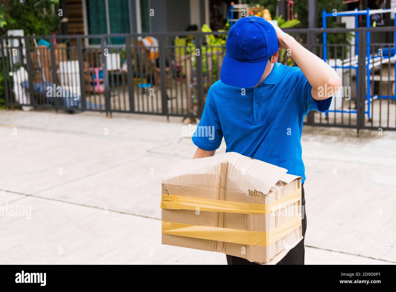 Asian young delivery man in blue uniform he emotional falling courier ...