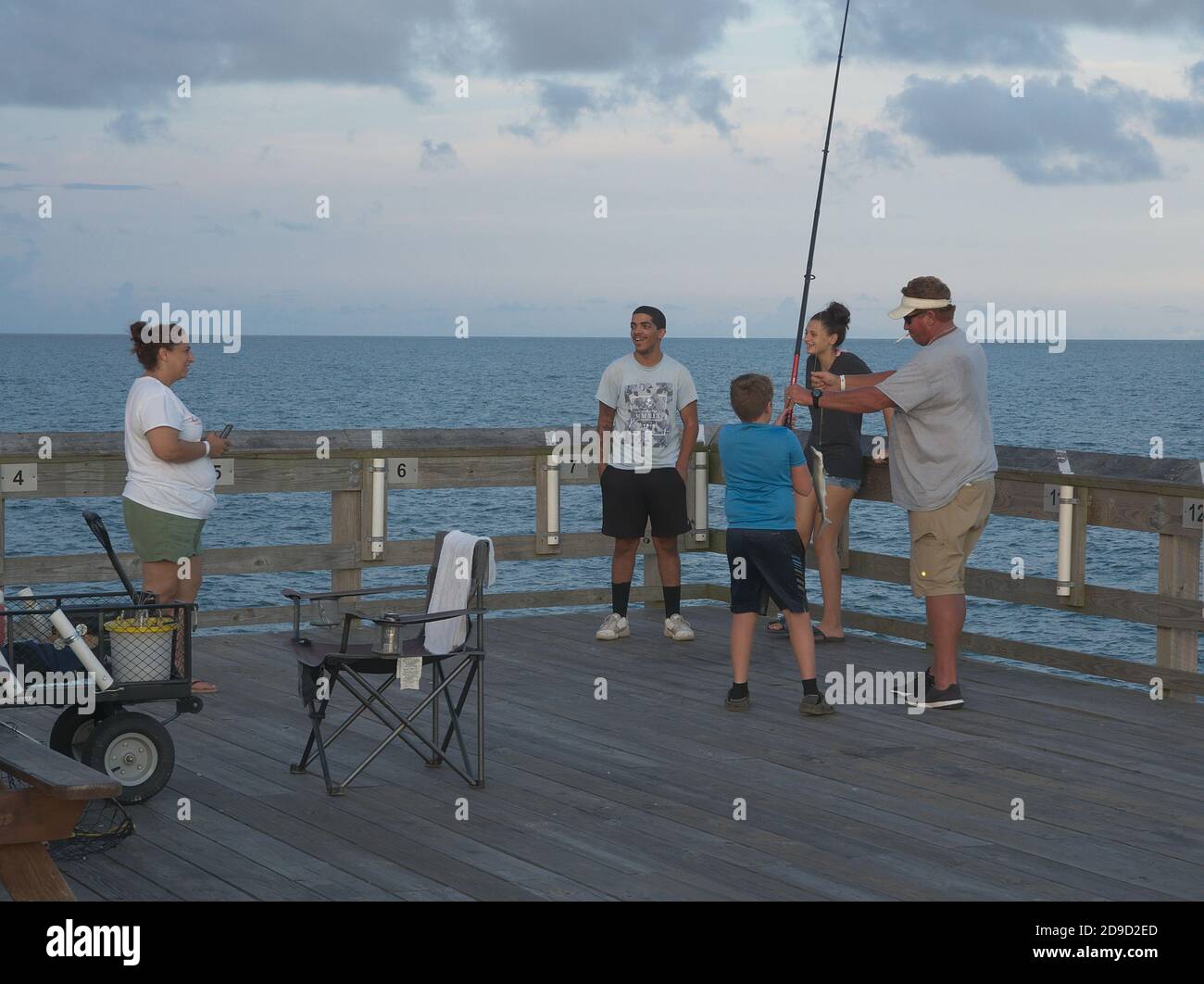 Father helping son get baby shark off his fishing line hook Stock Photo ...