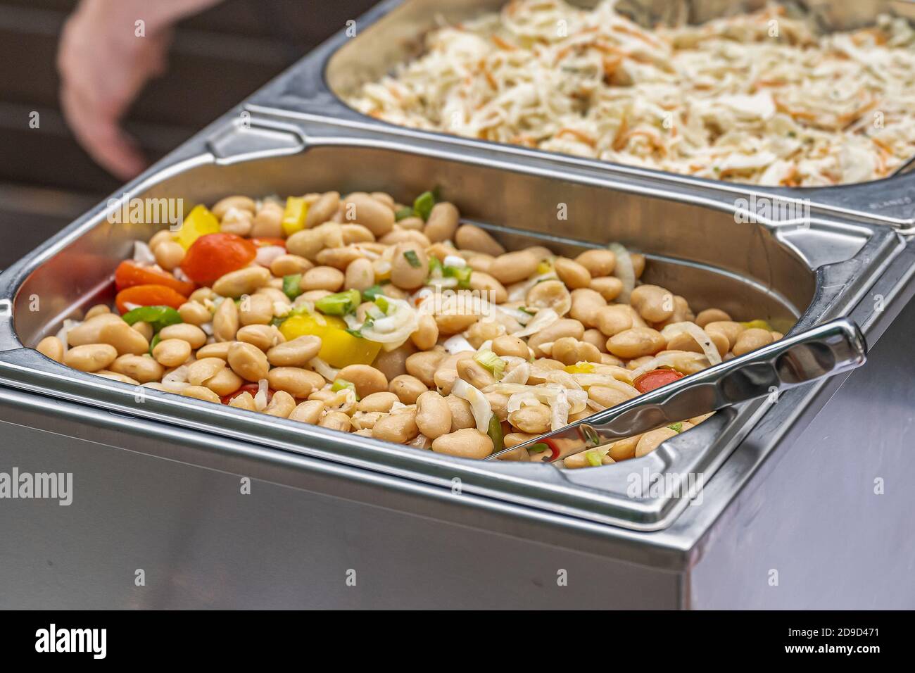 Fresh white beans stew cooking steaming in large wok pan during hotel ...