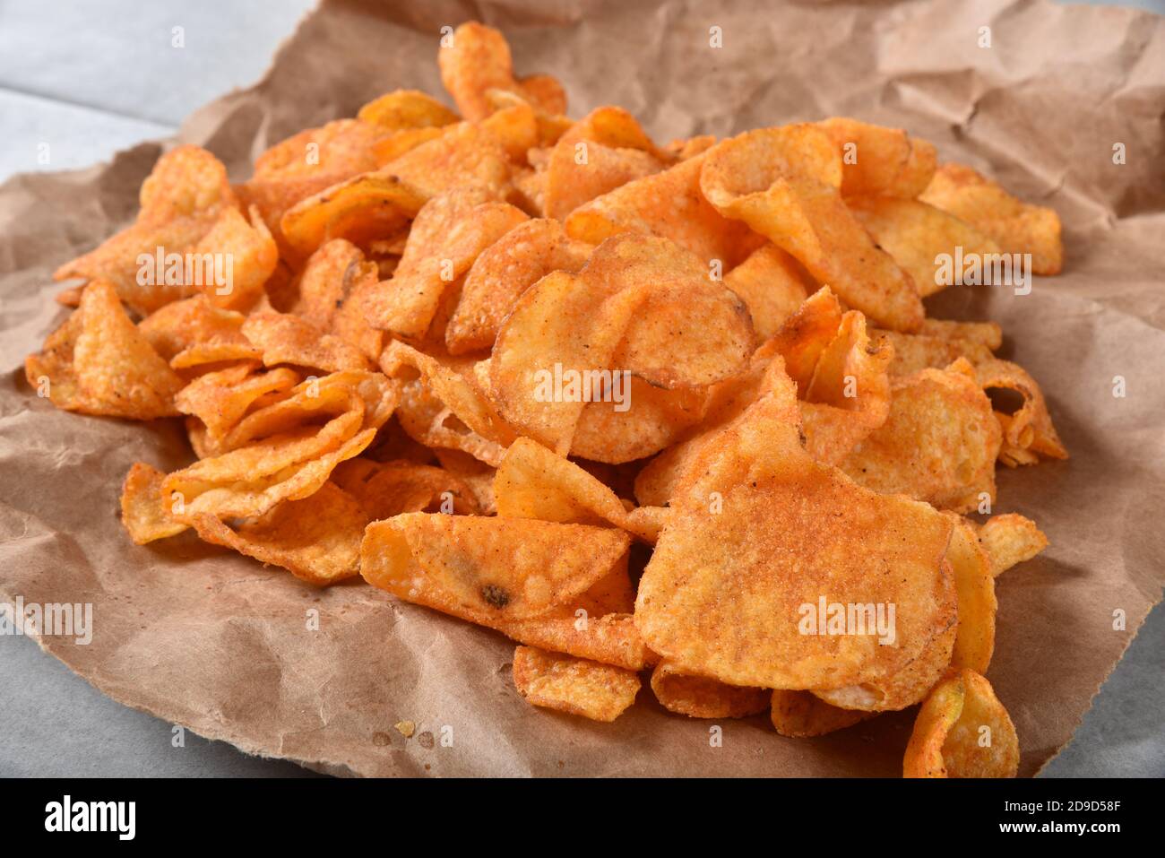 A mound of barbecued flavored potato chips on a brown paper wrapper ...
