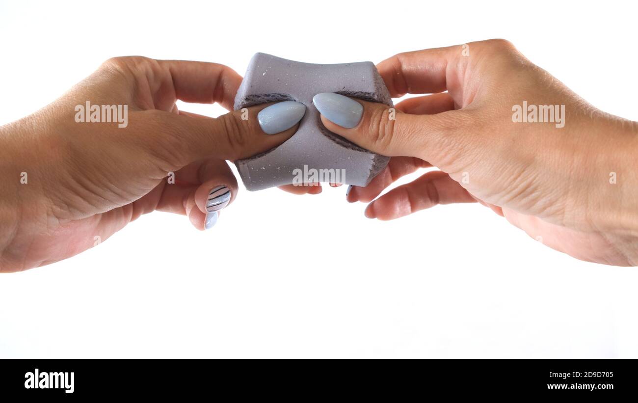 Female hands are molded from silver gray blue plasticine, developing ...