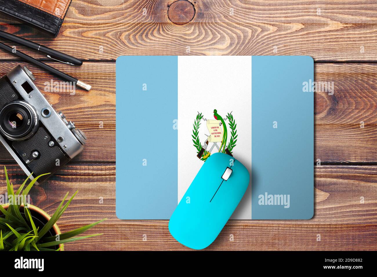 Guatemala flag on wooden background with blue wireless mouse on a mouse ...