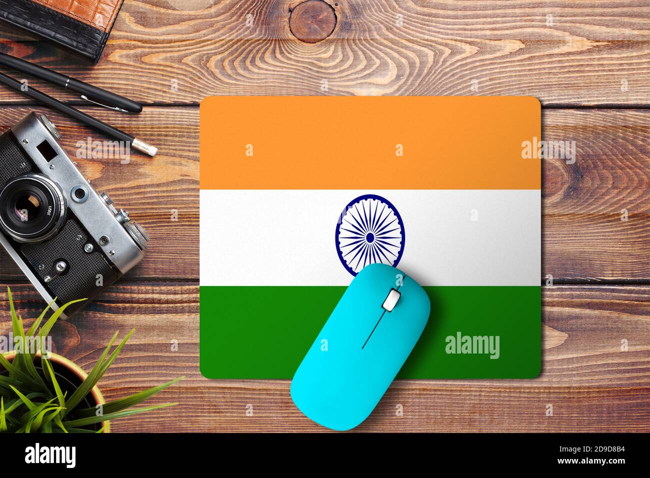 India flag on wooden background with blue wireless mouse on a mouse pad ...