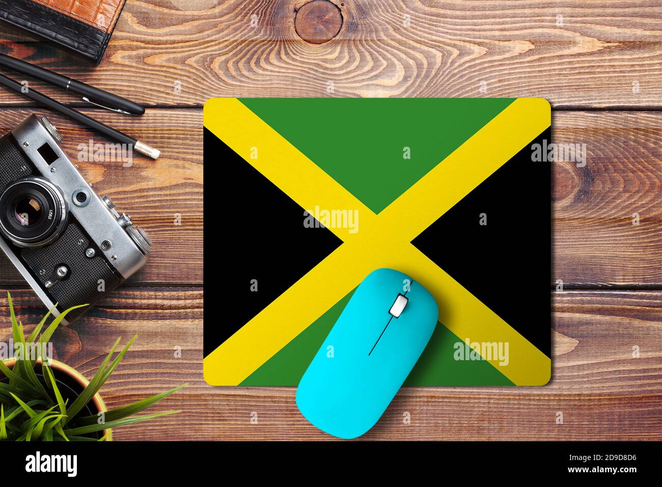 Jamaica flag on wooden background with blue wireless mouse on a mouse ...