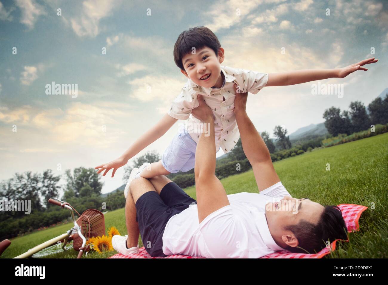Father and son lay on the grass to play Stock Photo - Alamy