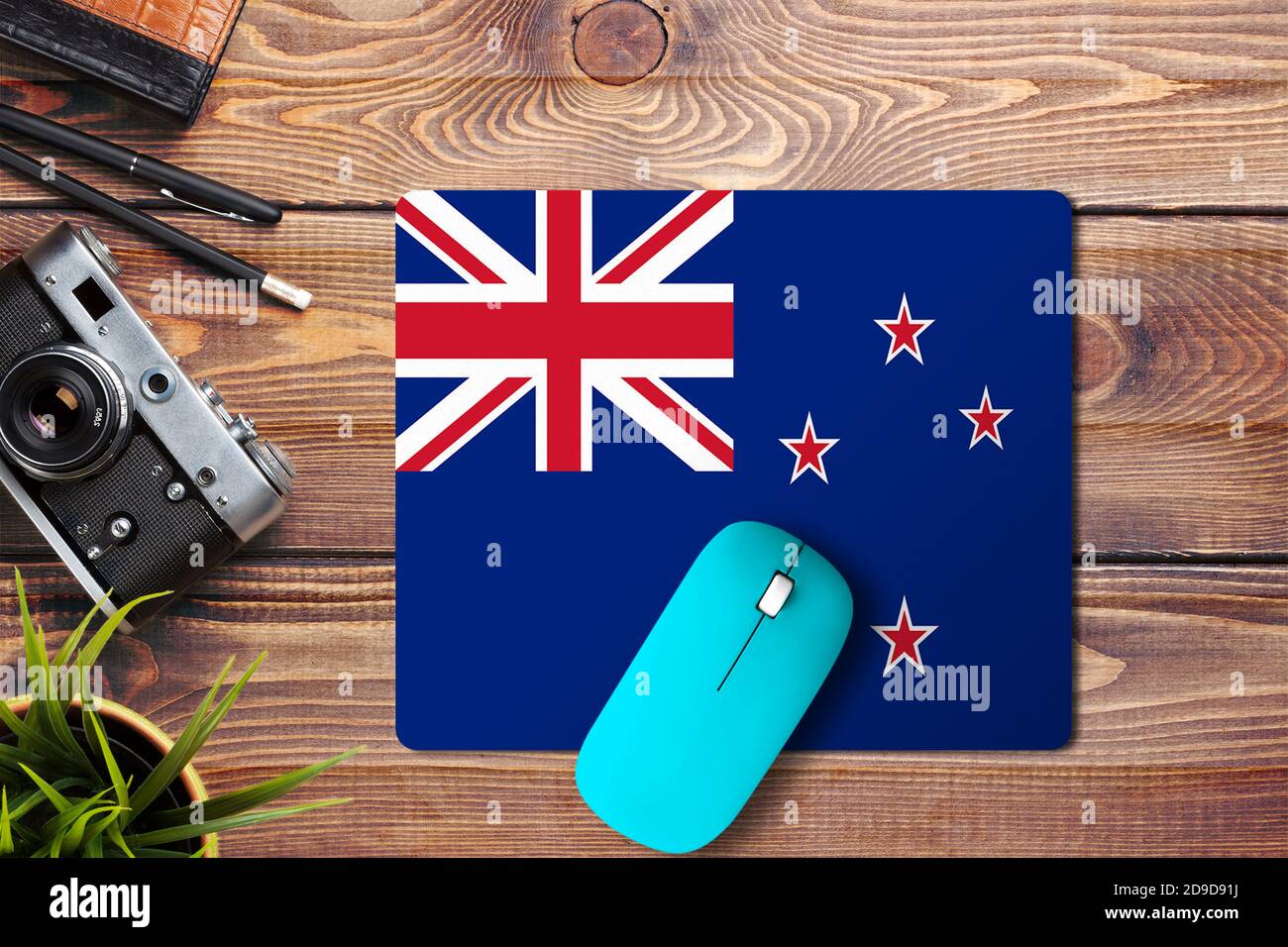 New Zealand flag on wooden background with blue wireless mouse on a ...