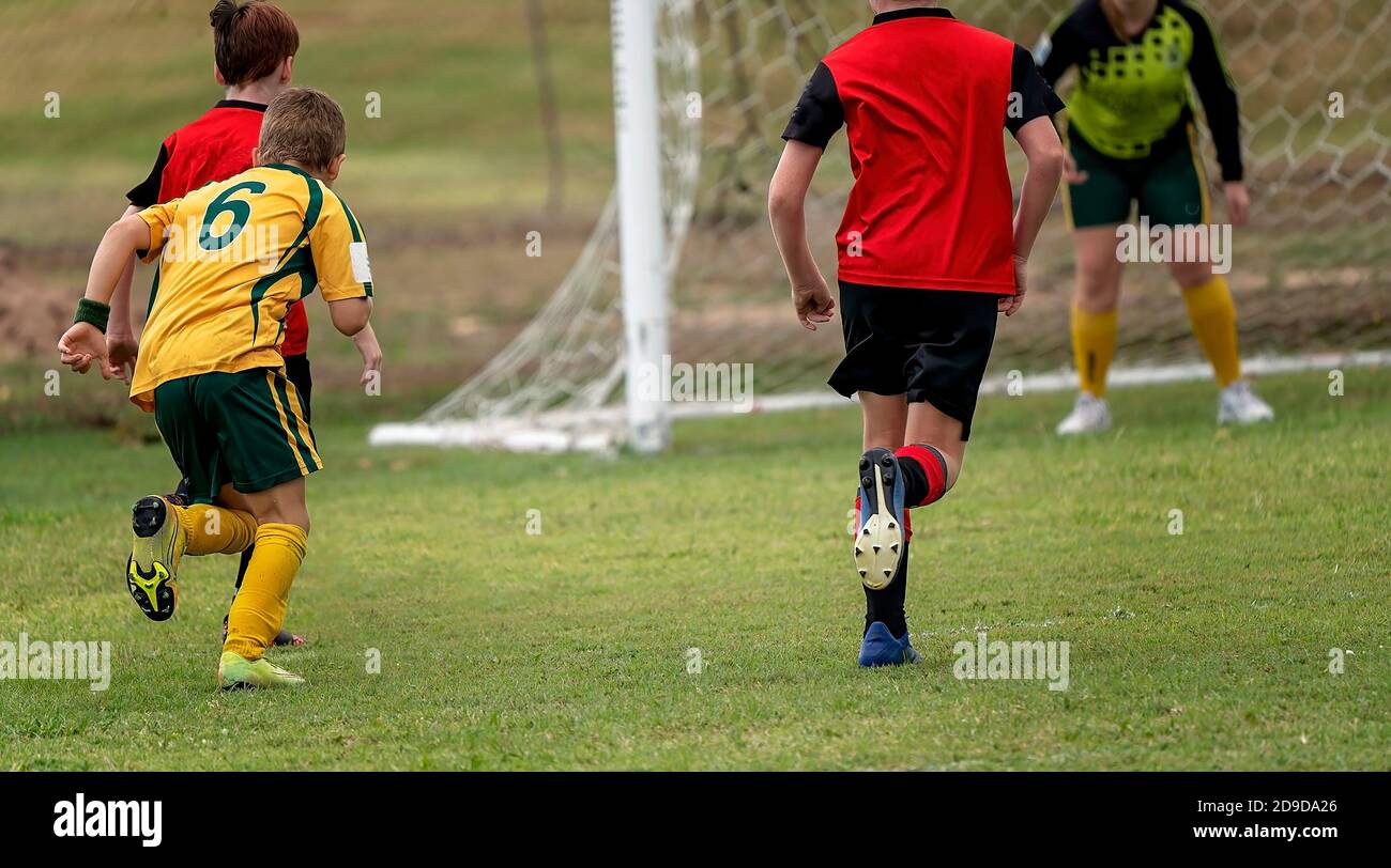 Young soccer players chase the ball on the field during a game Stock ...