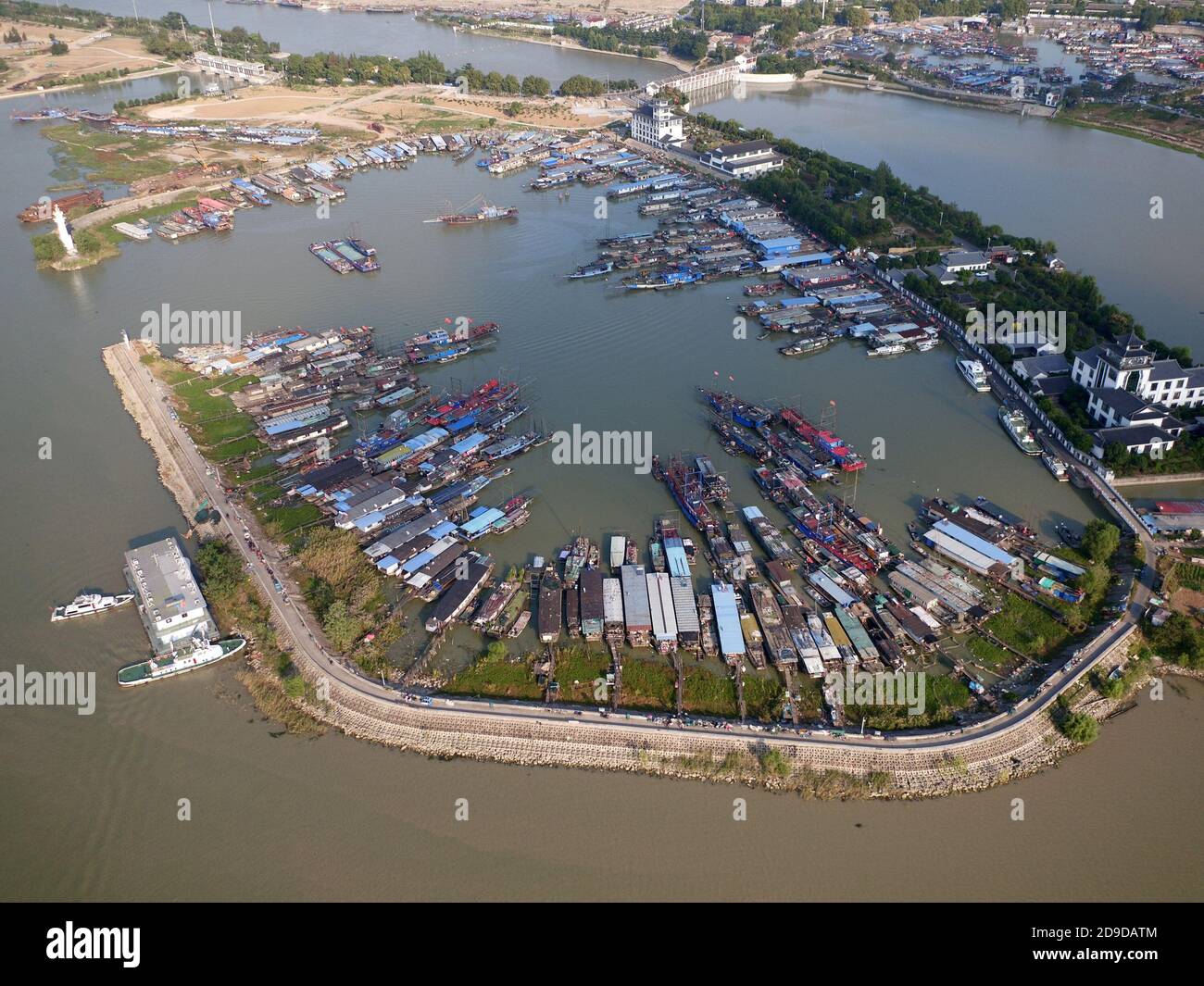 An aerial view of fishing boats anchoring around a harbor crowdedly as ...