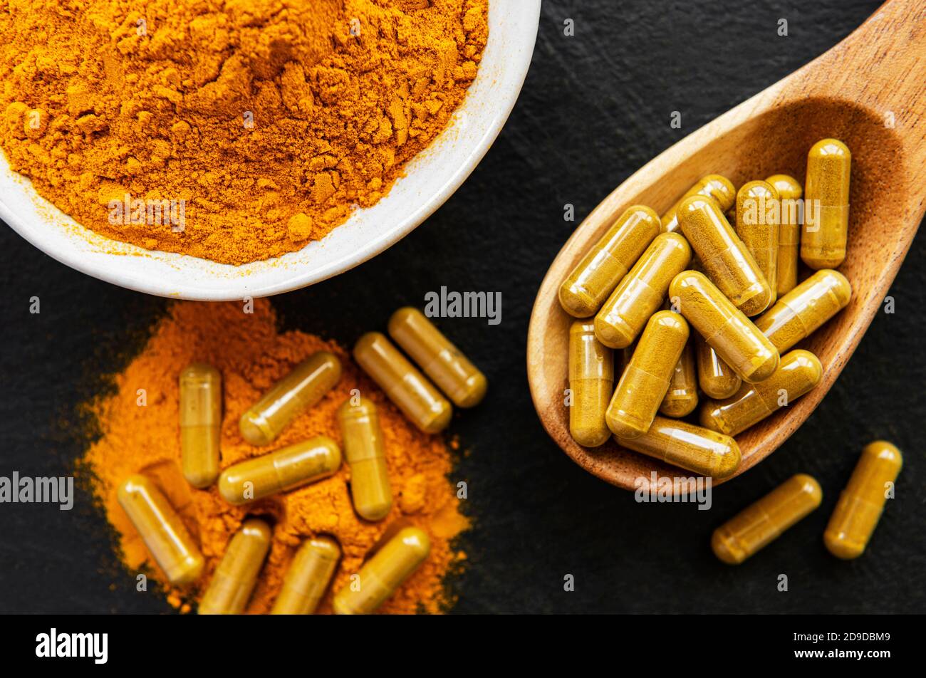 Turmeric powder and turmeric pills on a black concrete background Stock ...