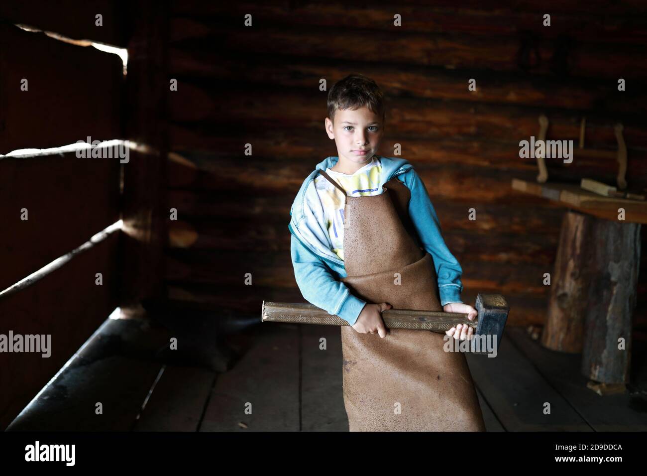 Portrait of kid holding hammer in forge Stock Photo - Alamy