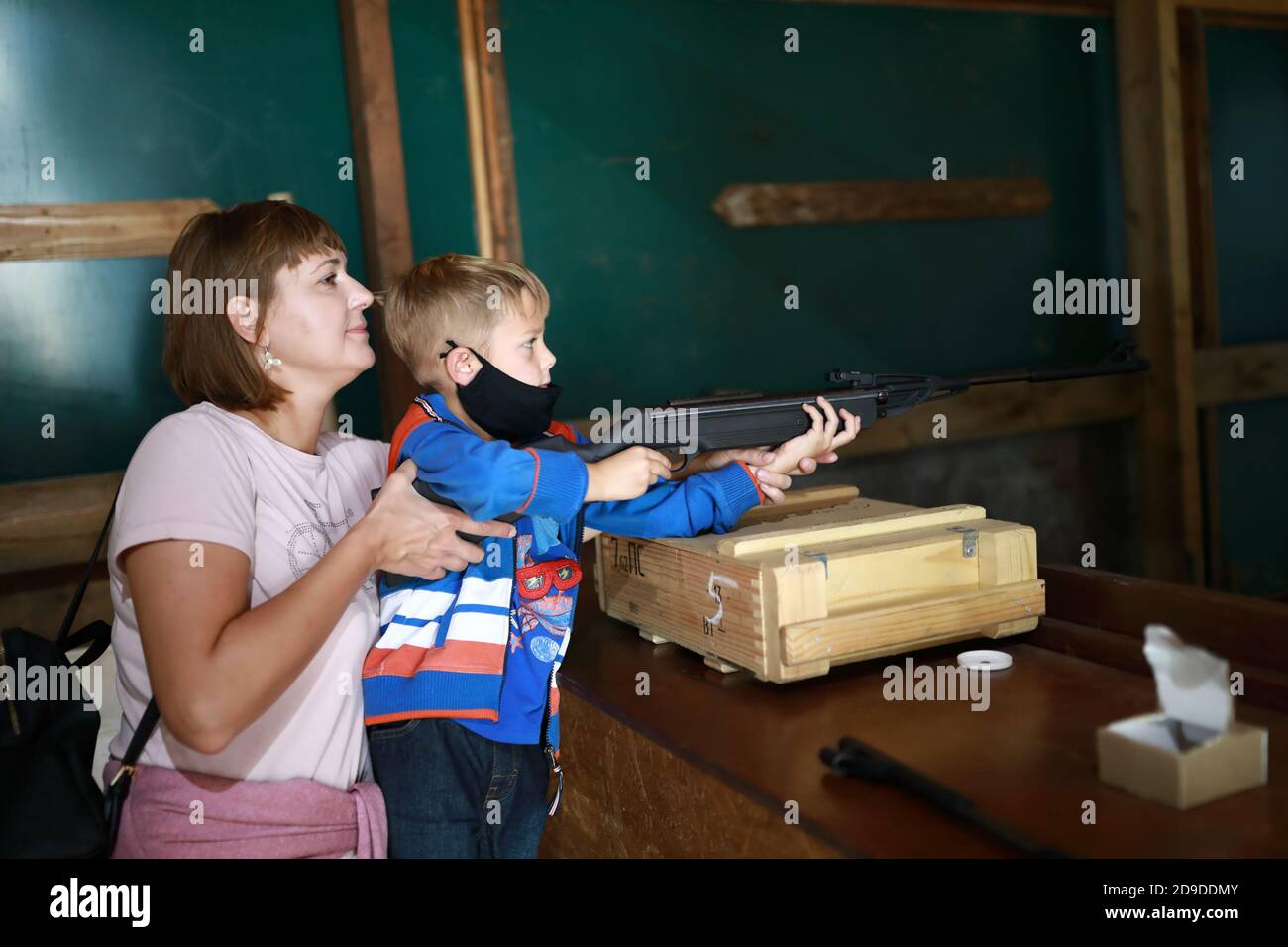 Mother with son shoot air rifle at shooting range Stock Photo - Alamy