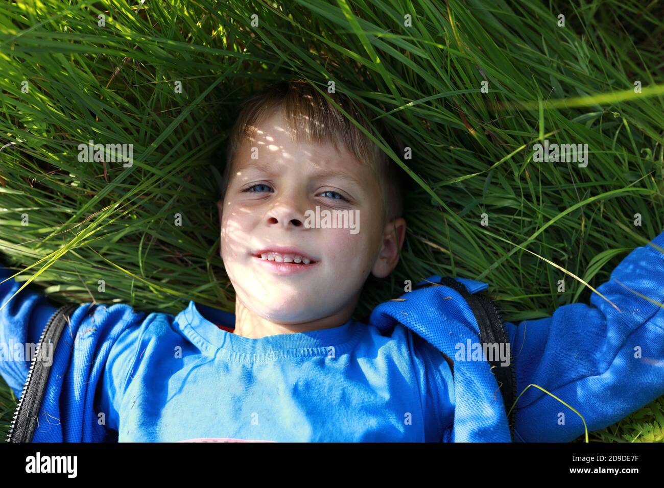 Boy lying on green grass of lawn, Karelia Stock Photo - Alamy
