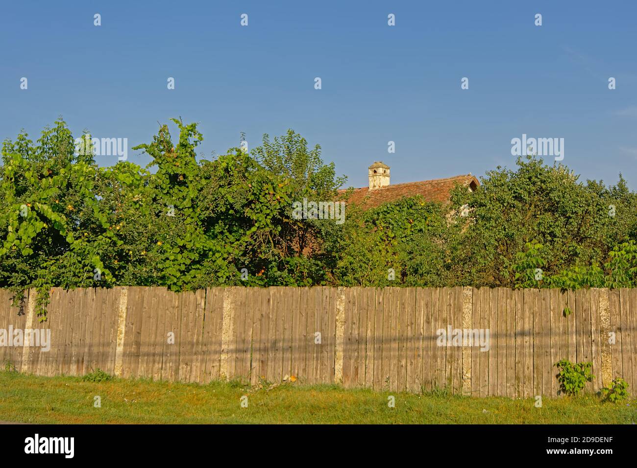 Old worn wooden fence around a farm with orchard in the village of ...