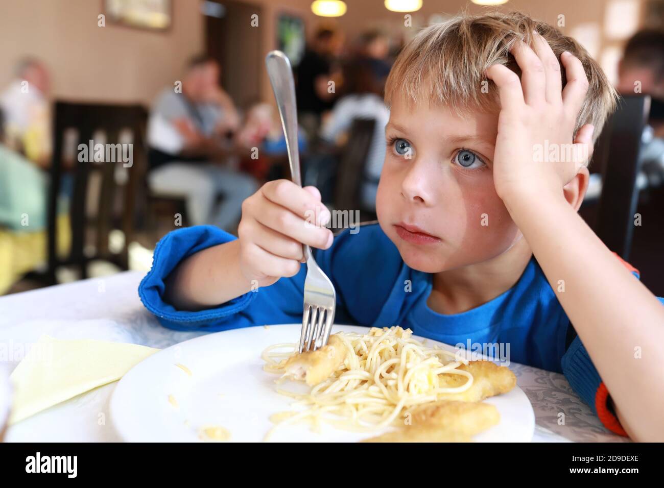 Boy eating spaghetti with nuggets in restaurant Stock Photo - Alamy