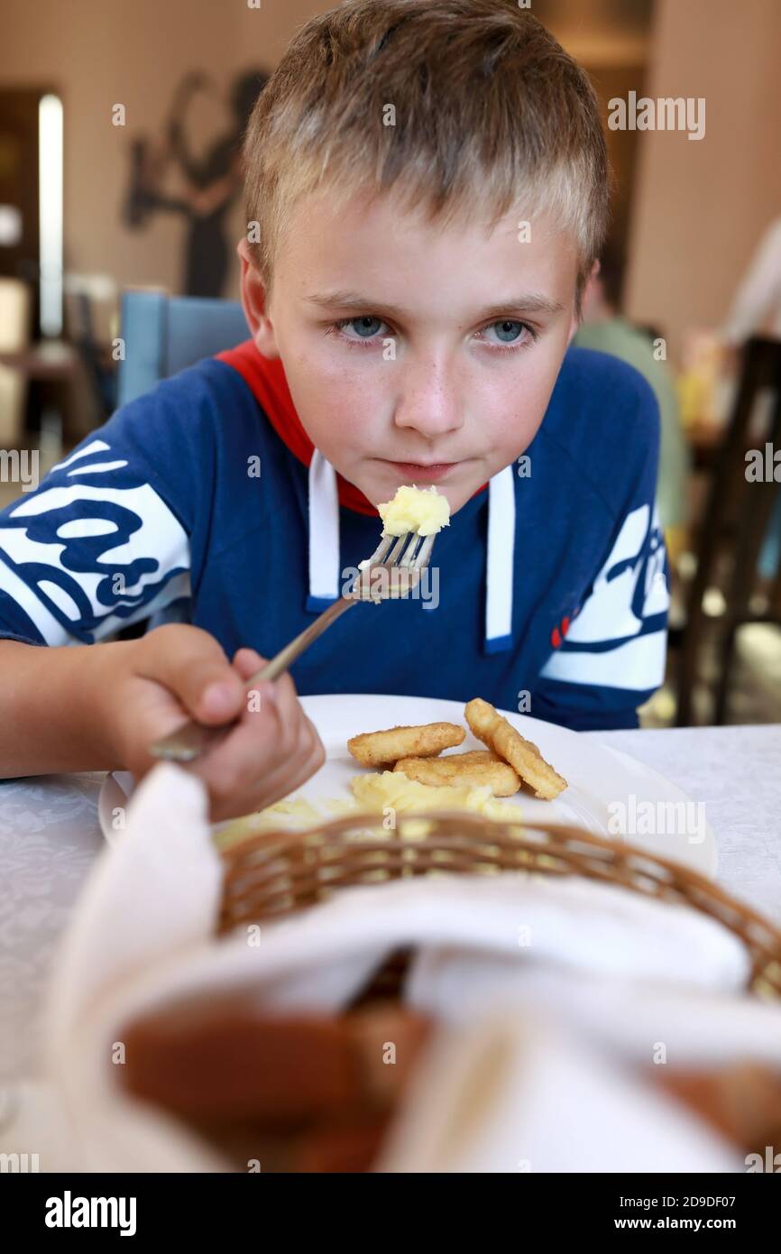 Kid eating nuggets with mashed potatoes in restaurant Stock Photo - Alamy